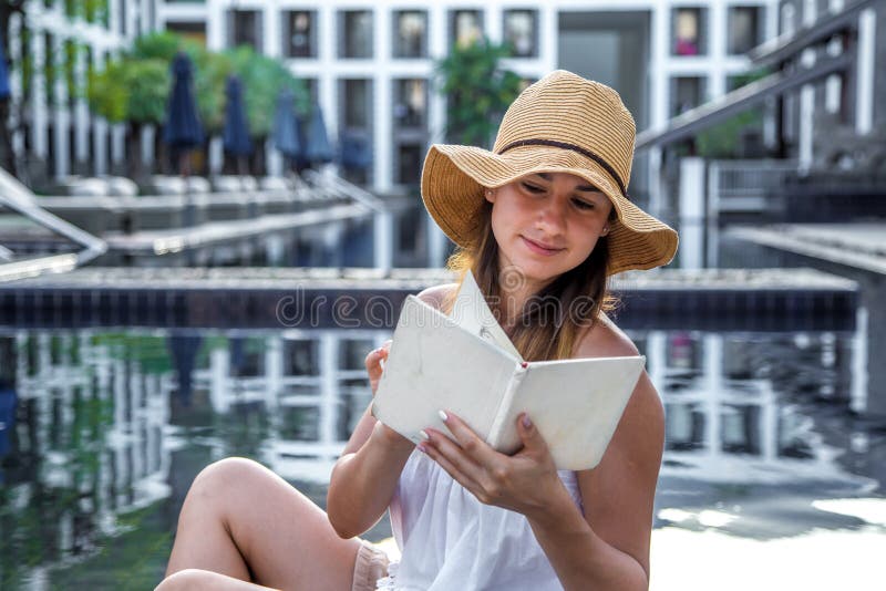 Girl in a Hat Reading a Book by the Pool Stock Image - Image of chair ...