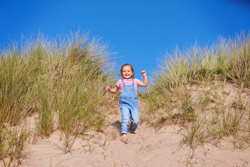 Young Girl Having Fun on Beach Vacation Running Down Sand Dunes Stock ...