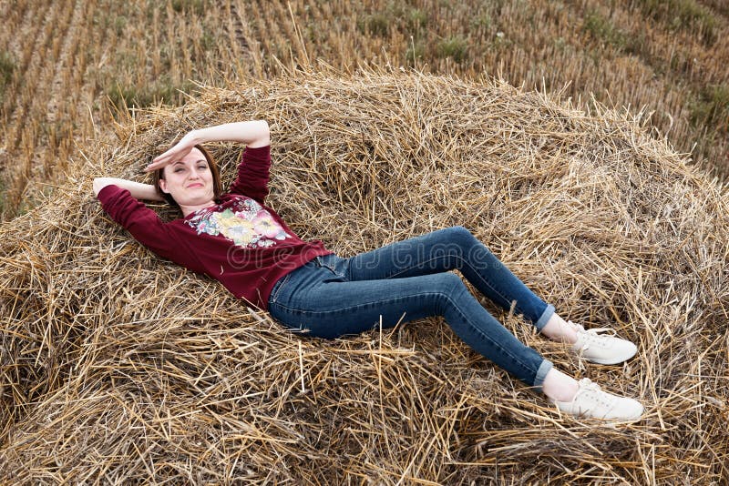 Young Girl Having Fun in the Field, Lying on a Haystack Stock Photo ...