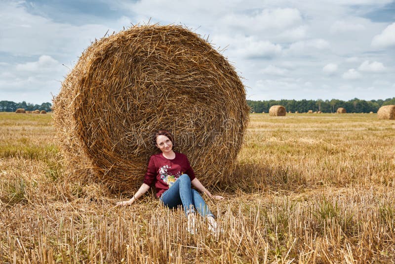 Young Girl Having Fun in the Field, Sits in a Haystack and Relaxing ...