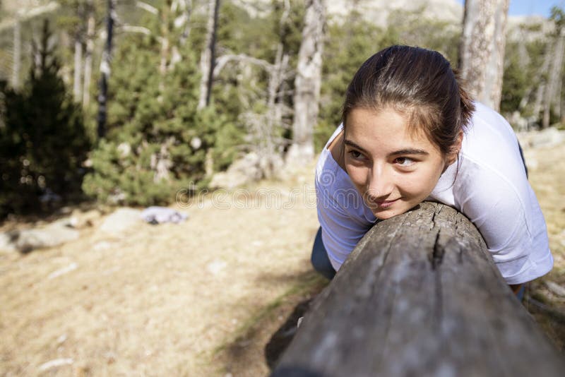 Young Girl Held To a Log while Looking at the Camera in the Forest ...