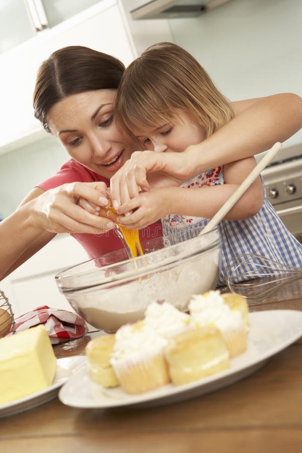 Young Girl Helping Mother To Bake Cakes in Kitchen Stock Photo - Image ...