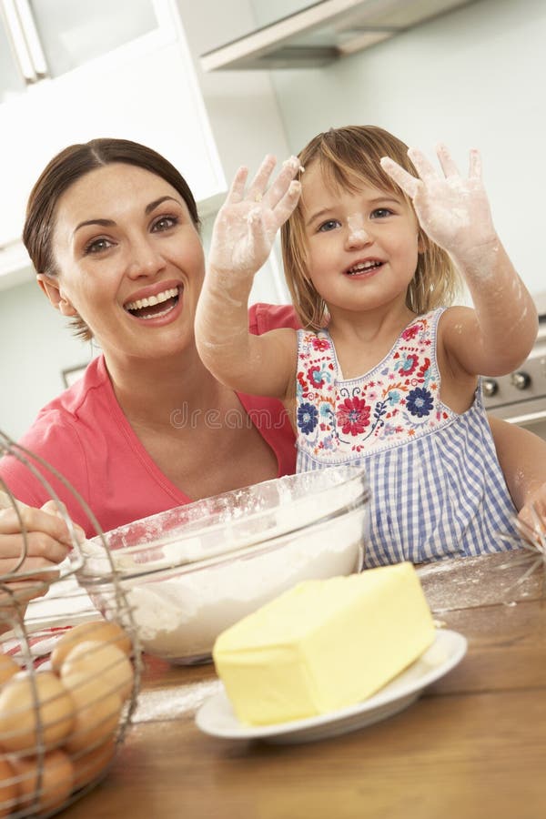 Young Girl Helping Mother To Bake Cakes in Kitchen Stock Photo - Image ...