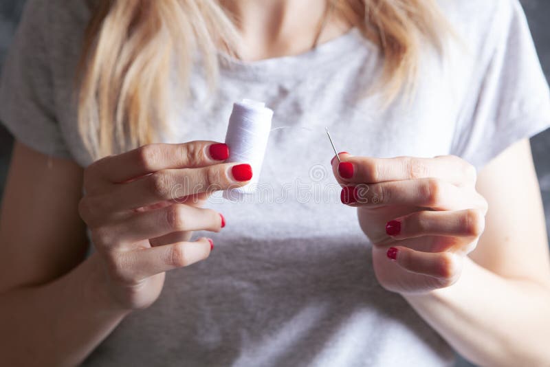 Young Girl Holding a Thread and a Needle Stock Photo - Image of ...