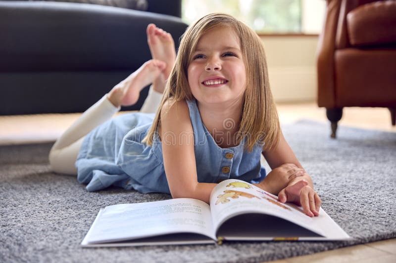 Young Girl at Home Lying on Floor of Lounge Reading Book Stock Image ...