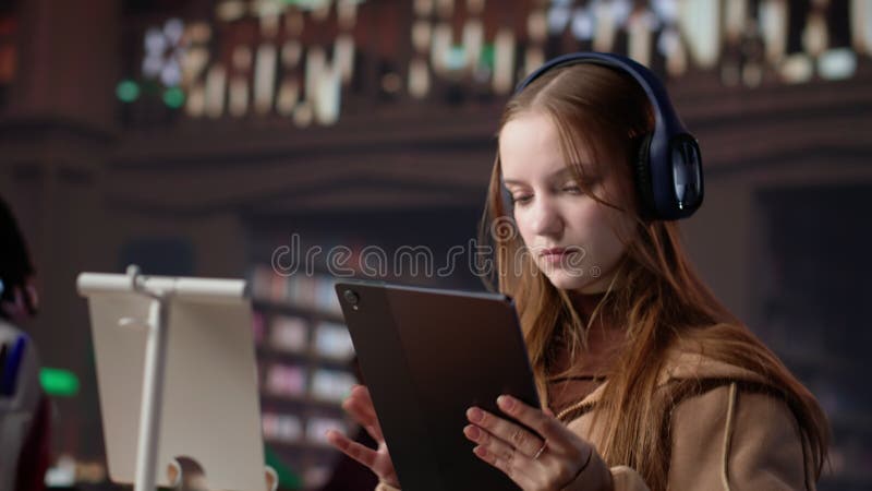 Young Girl Listening To Educational Documentary on Laptop and Taking ...