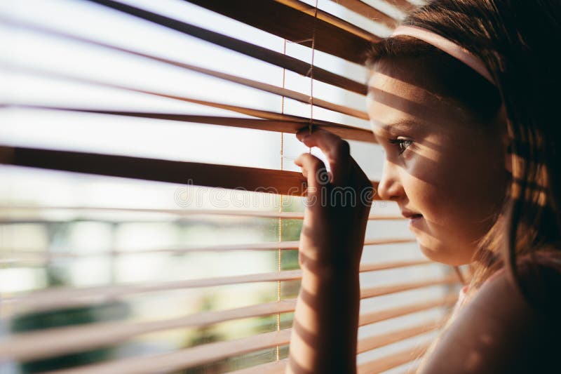 Young Girl Looking through Blinds Stock Photo - Image of blinds ...