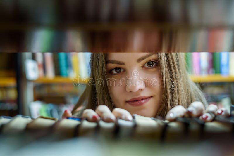 Young Girl Looking for Book on Bookshelf in Library Stock Image - Image ...