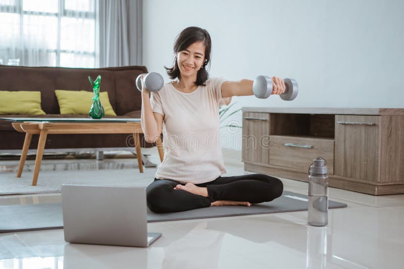 Young Girl Looking at Laptop and Doing Exercises at Home. Stock Photo ...