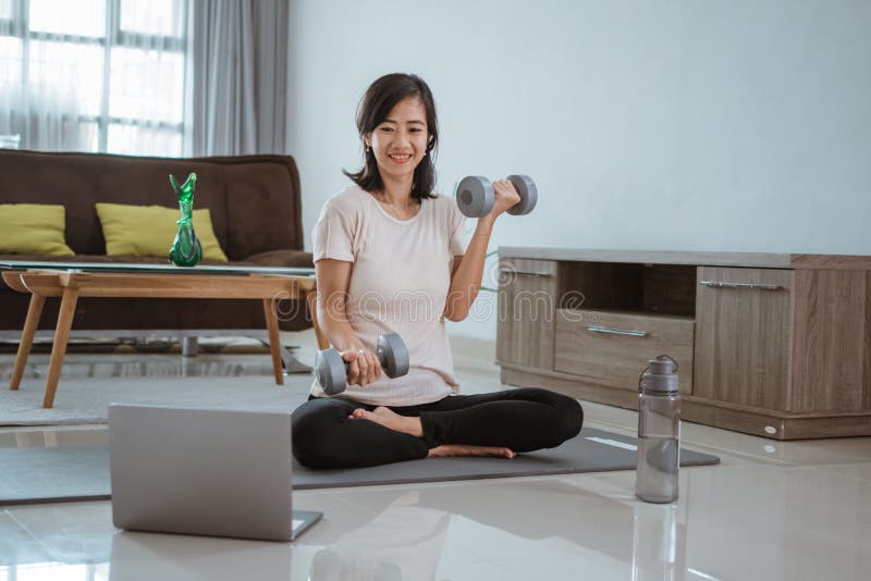 Young Girl Looking at Laptop and Doing Exercises at Home. Stock Photo ...