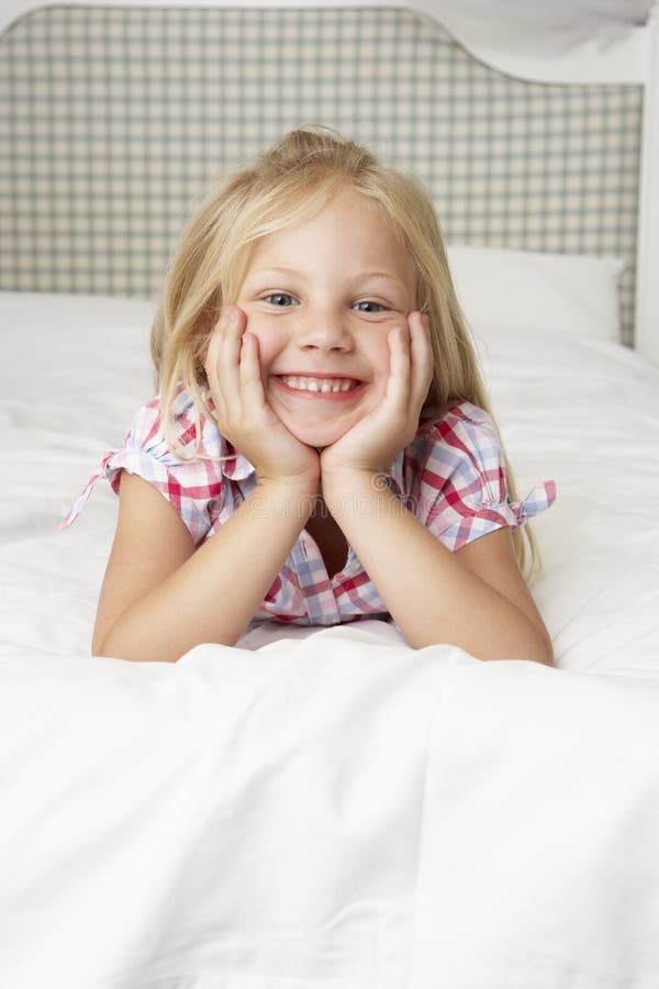 Young Girl Lying on Bed Smiling Stock Photo - Image of indoors, person ...