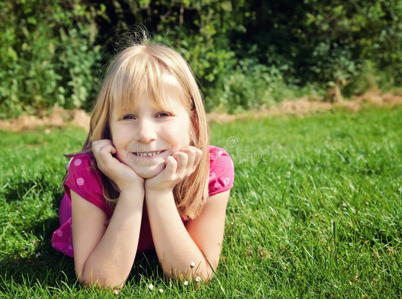 Young girl lying on grass stock photo. Image of beautiful - 55162362