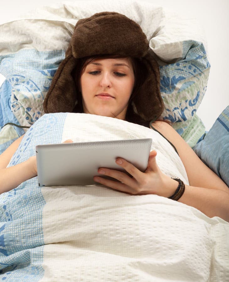 The Girl is Lying Sick in Bed and Looking into Her Tablet Stock Photo ...