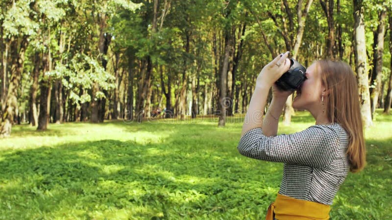 A Young Girl Photographer with a Camera Poses in the Park. Stock ...