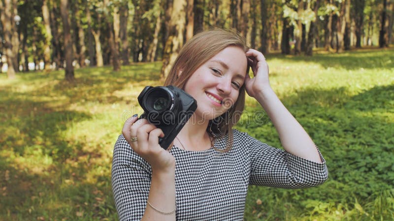 A Young Girl Photographer with a Camera Poses in the Park. Stock Image ...