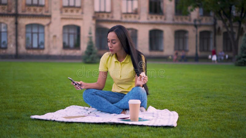 Young Girl on a Picnic. Girl Scrolls the Phone and Eats a Sandwich 4K ...