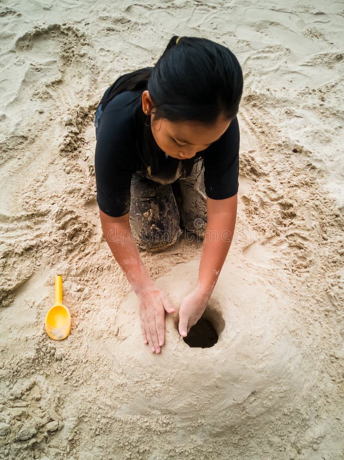 A Young Girl is Playing with Sand on Beach. Vacation Concept Stock ...