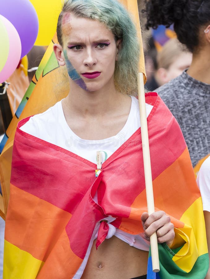 A Young Girl With A Rainbow Flag Attending The Gay Pride Parade Also