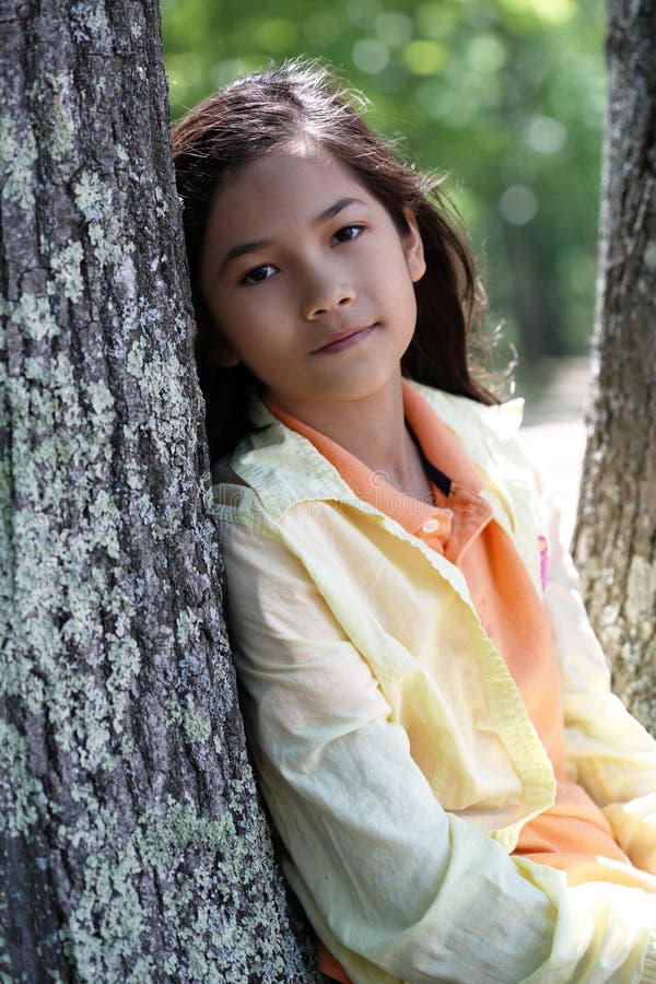 Young Girl Relaxing Against Tree Stock Photo - Image of asian, smiling ...