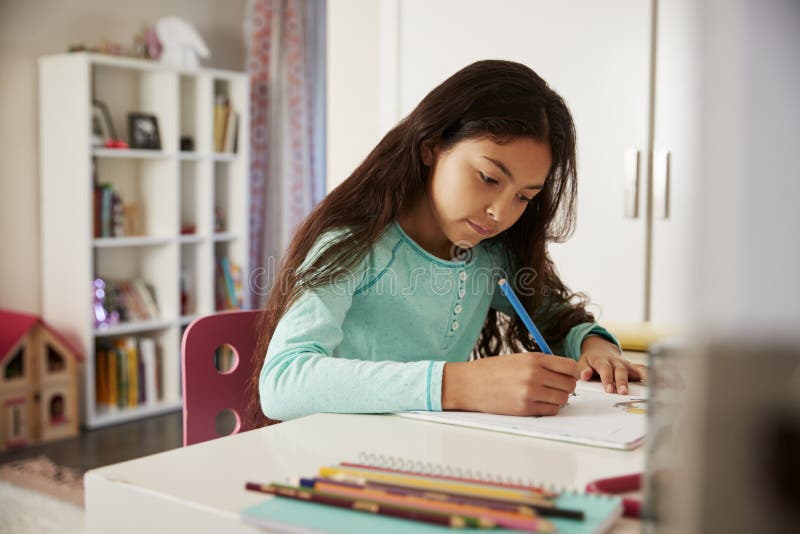 Young Girl Sitting at Desk in Bedroom Doing Homework Stock Photo ...