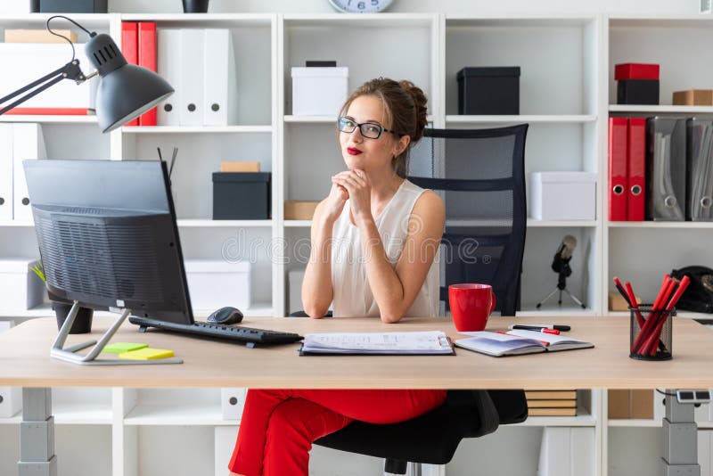 A Young Girl is Sitting at the Desk in the Office. Stock Photo - Image ...