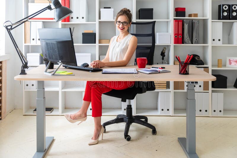 A Young Girl is Sitting at the Desk in the Office. Stock Photo - Image ...