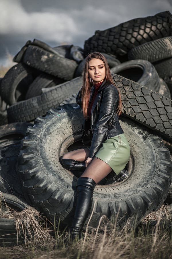 Girl sitting in the tyres stock photo. Image of apocalypse - 150820618