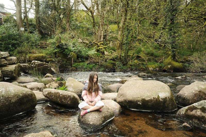Young Girl Sitting on a Rock in a River, Looking Thoughtful. Stock ...