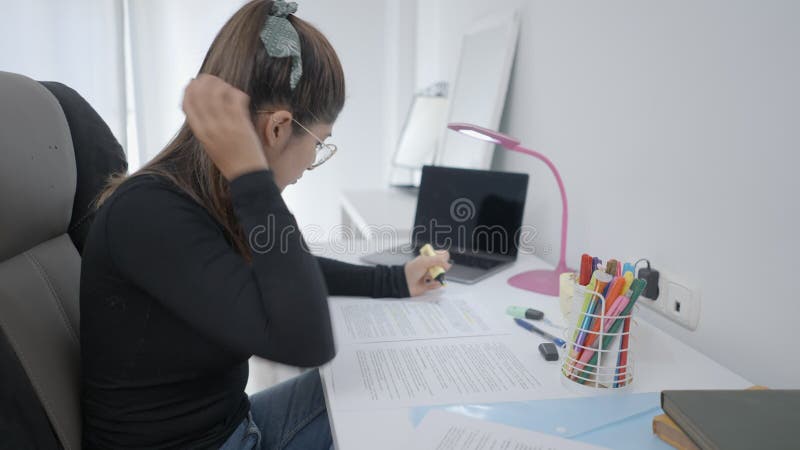 A Young Girl Sitting at a Study Table and Highlighting Her Study ...
