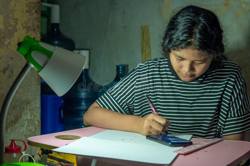 A Young Girl Student Studying at Home Under a Desk Lamp Stock Image ...