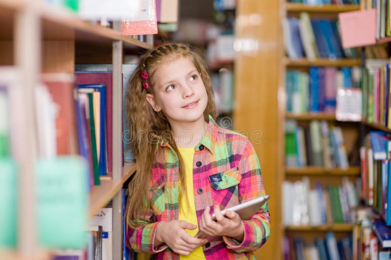 Young Girl Using a Tablet Computer in a Library Stock Image - Image of ...