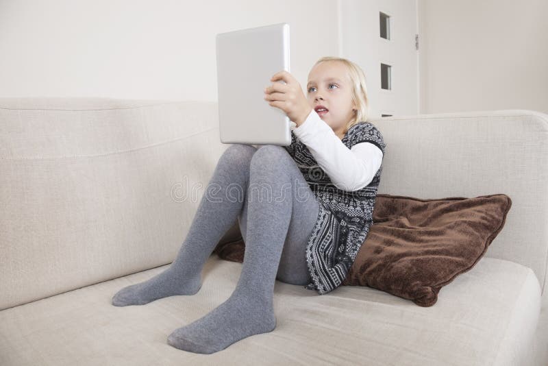 Young Girl Using Tablet PC on Sofa Stock Photo - Image of quality ...