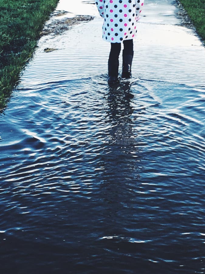 Young Girl Walking through Puddle Stock Image - Image of reflection ...