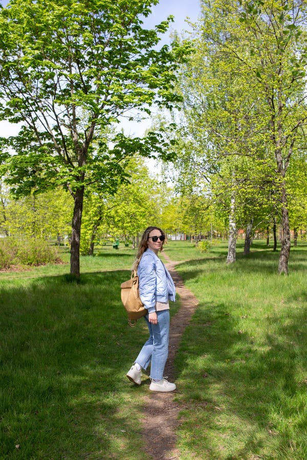 A Young Girl Walks Alone in the Park with a Backpack Stock Photo ...
