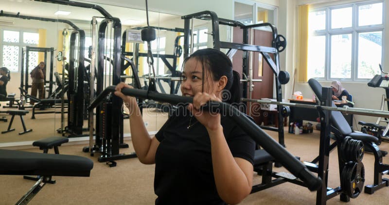 Young Girl Working Out on a Lat Pulldown Machine in the Gym, Stock ...