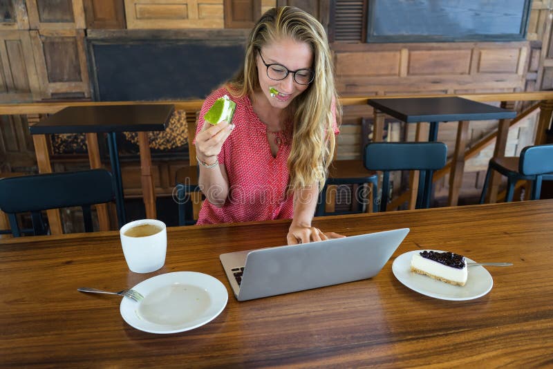 The Young Girl Works at the Computer and Cake, Food at the Computer, a ...