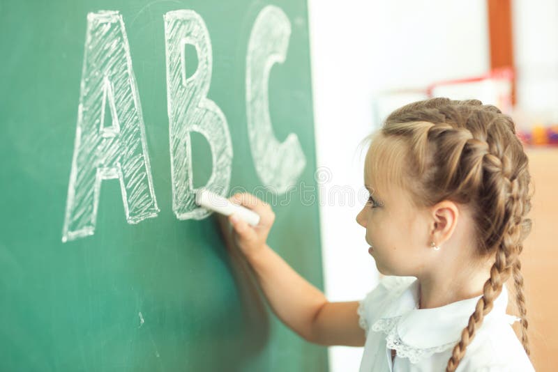 Young Girl Writing ABC on Green Chalkboard Stock Image - Image of used ...