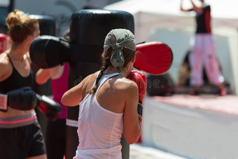 Young Girls Doing Fitness And Boxing Workout With Black Punching Bag