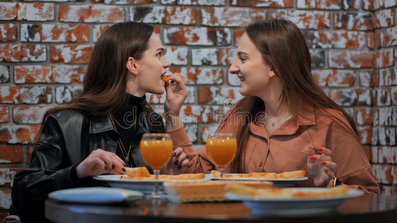 Young Girls Eat in a Cafe and Feed Each Other. Stock Photo - Image of ...