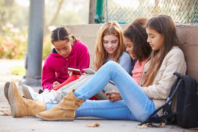 Young Girls Using Digital Tablets and Mobile Phones in Park Stock Image ...