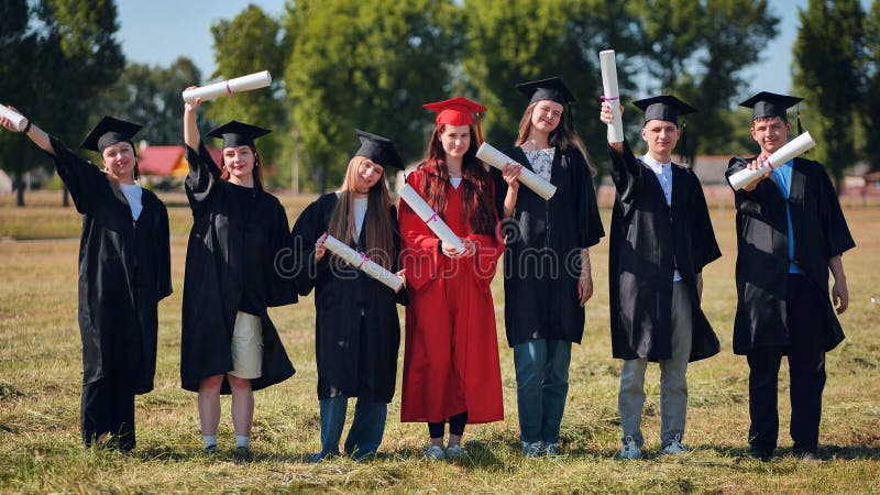 Young Graduates Pose with Diplomas in Hand on the Street. Stock Photo ...