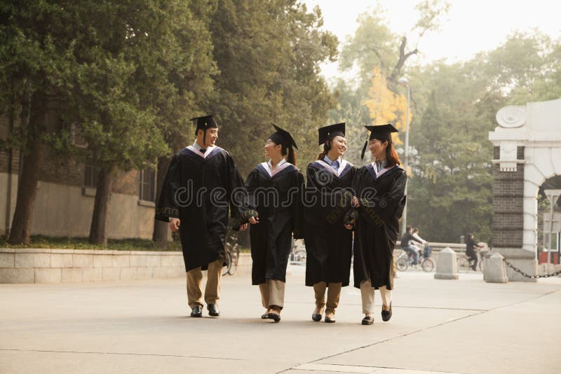 Young Graduates Walking Across Campus Stock Photo - Image of education ...