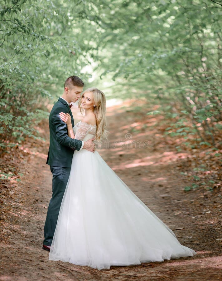 A Man in a Suit Hugs a Woman in an Evening Dress by the Waist Stock ...