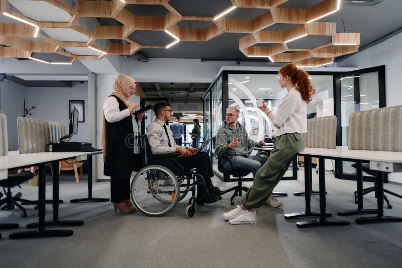 Young Group of Business People Brainstorming Together in a Startup Space, Discussing Business ...