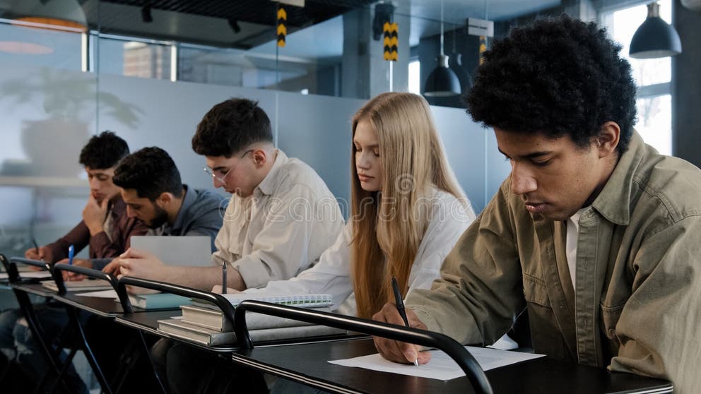 Young Group of Diverse Serious People Writing College Entrance Exam ...