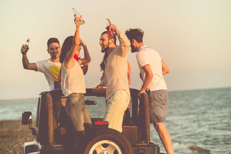 Young Group Having Fun on the Beach and Dancing in a Convertible Car ...