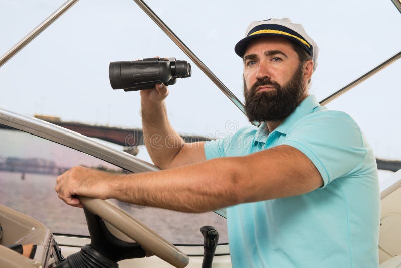 A Young Guy with a Beard Sails on a Yacht at the Helm with Binoc Stock ...