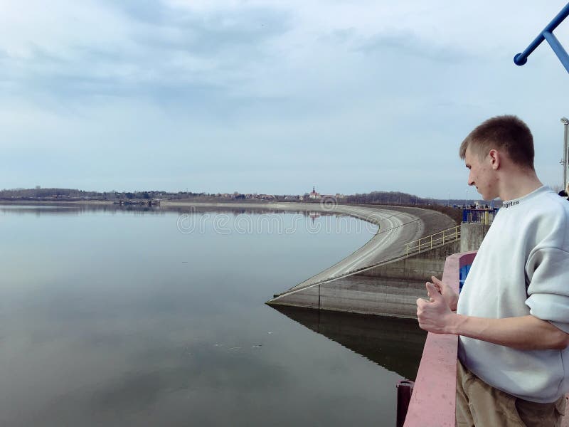 The Young Guy on the Bridge Looks at the Big River with Interest and ...