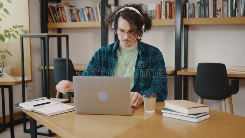 Young Guy College Student Sit at Desk Use Pc Laptop Computer Watching ...