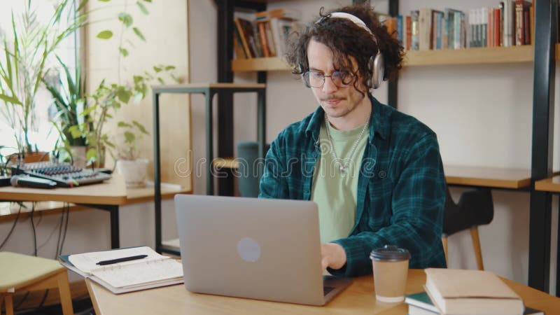 Young Guy College Student Sit at Desk Use Pc Laptop Computer Watching ...